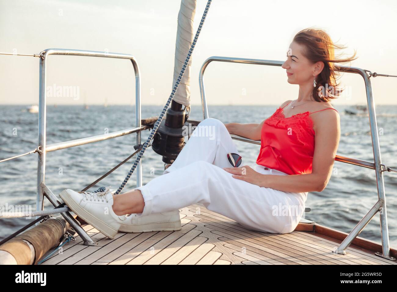 Joyful woman middle age portrait on deck of sailing yacht enjoying ...
