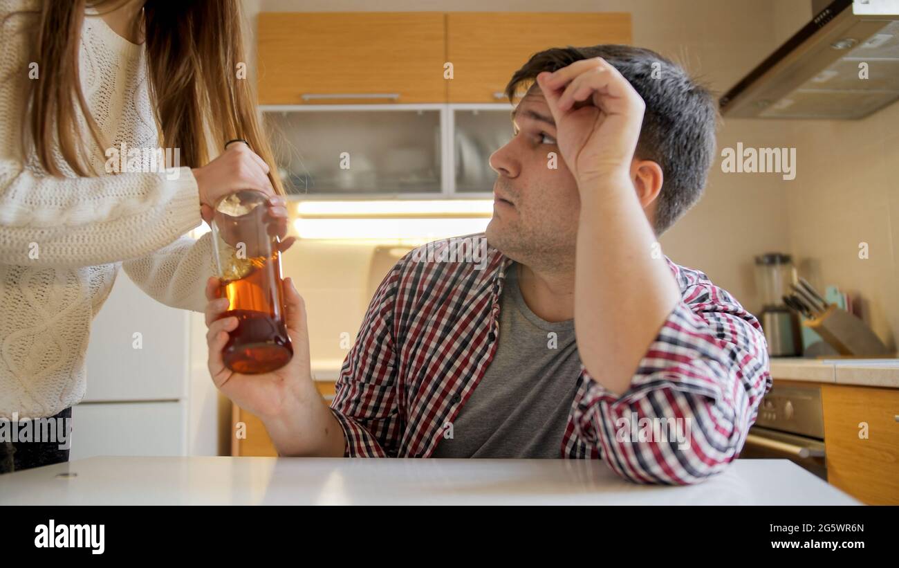 Teenage daughter taking bottle with alcohol from addicted father ...