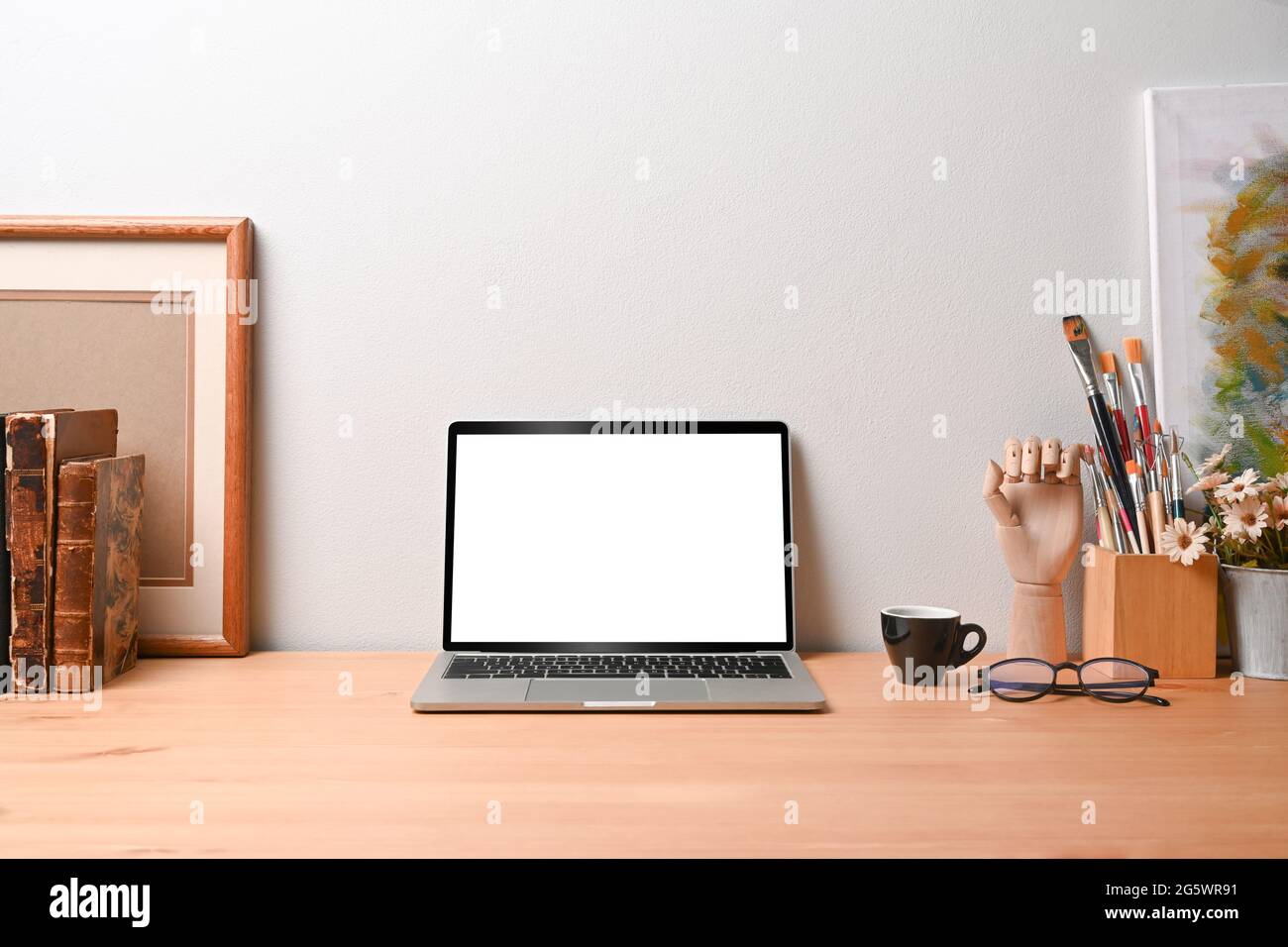 Laptop computer, empty photo frame, books, pencil holder and coffee cup ...