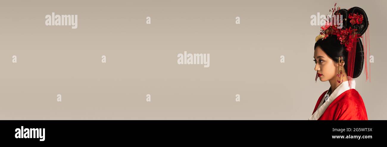 Side view of asian woman with decor in hairdo isolated on grey, banner ...