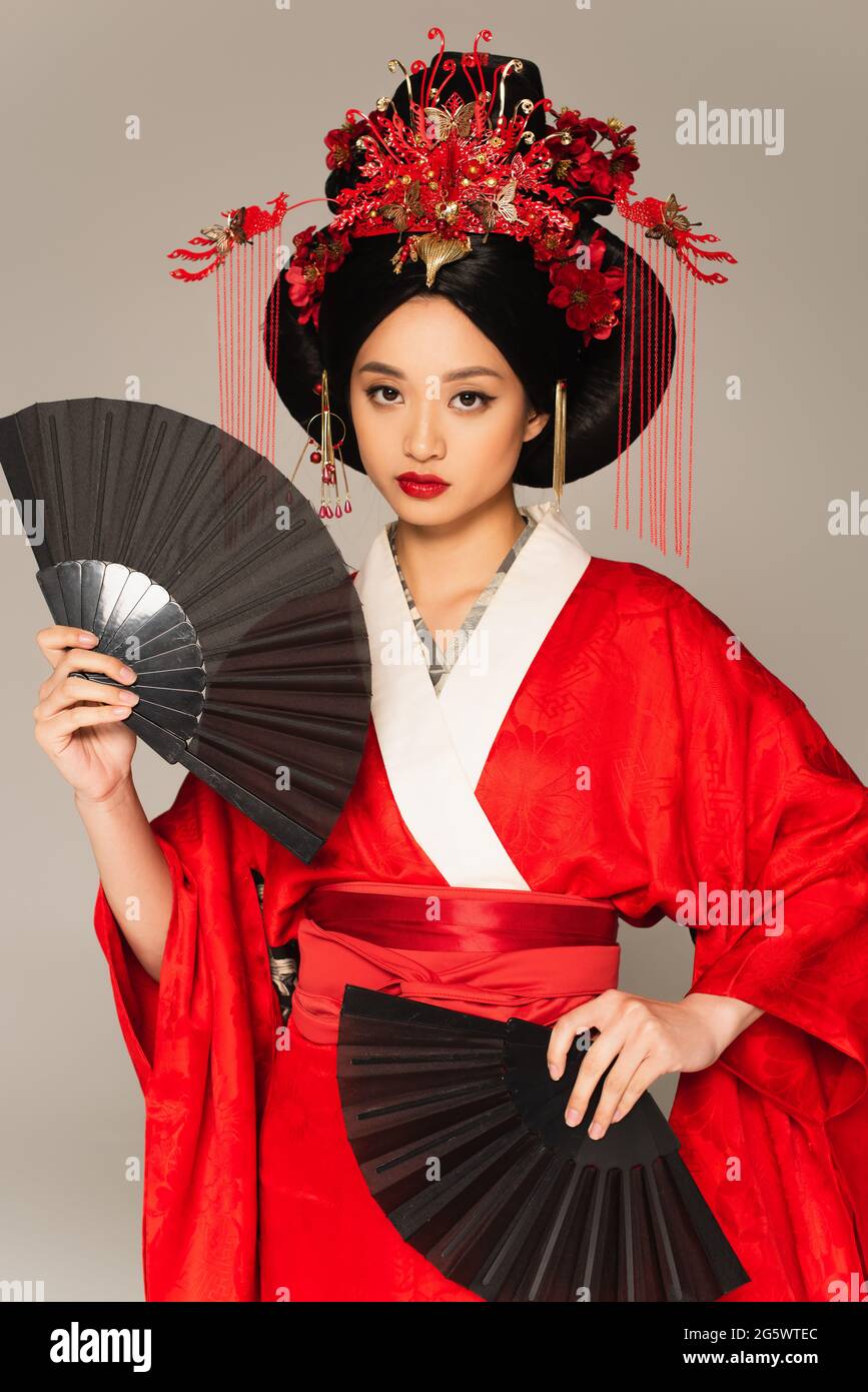 Young japanese woman with fans looking at camera isolated on grey Stock ...