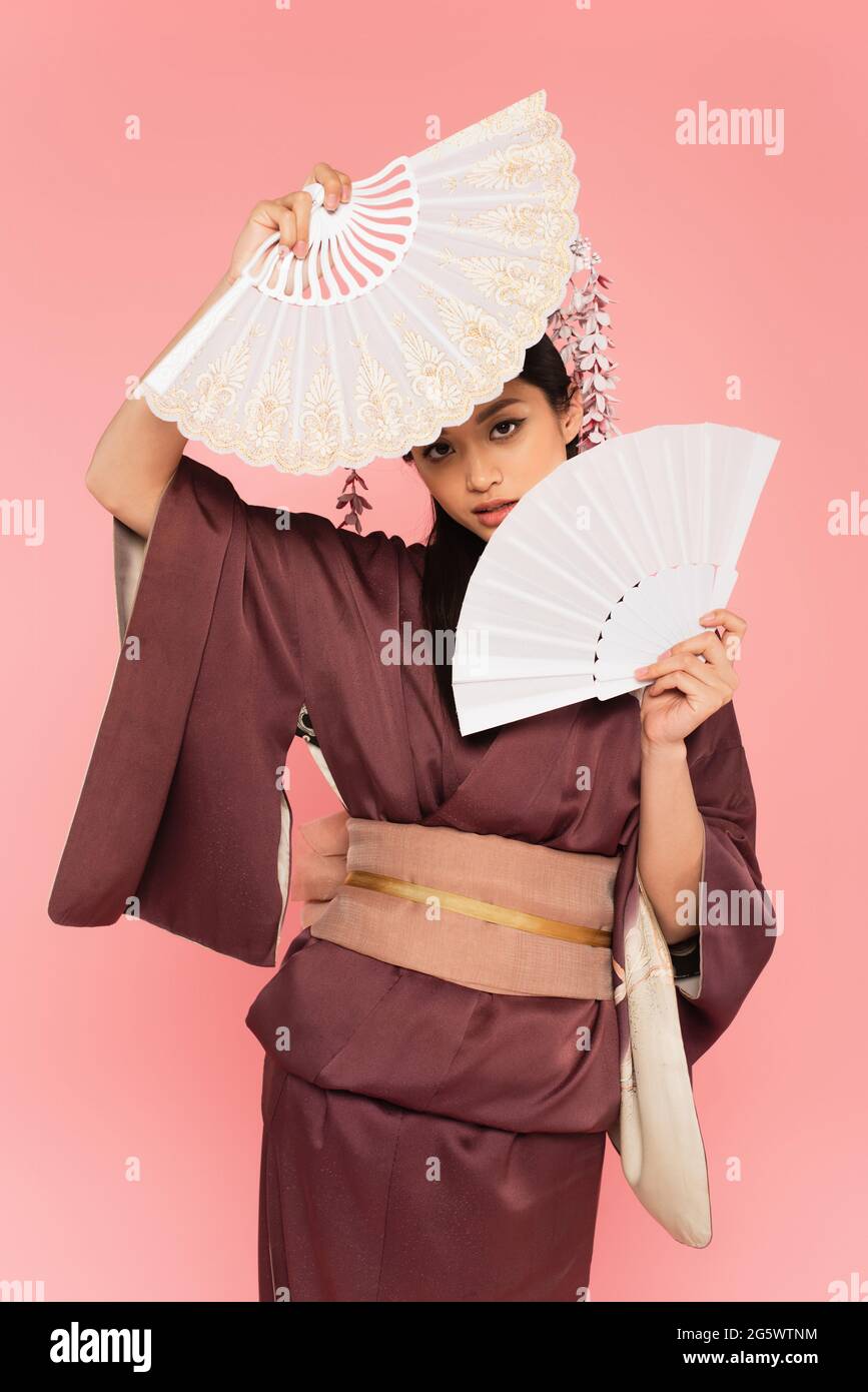 Young asian woman holding fans near face isolated on pink Stock Photo ...