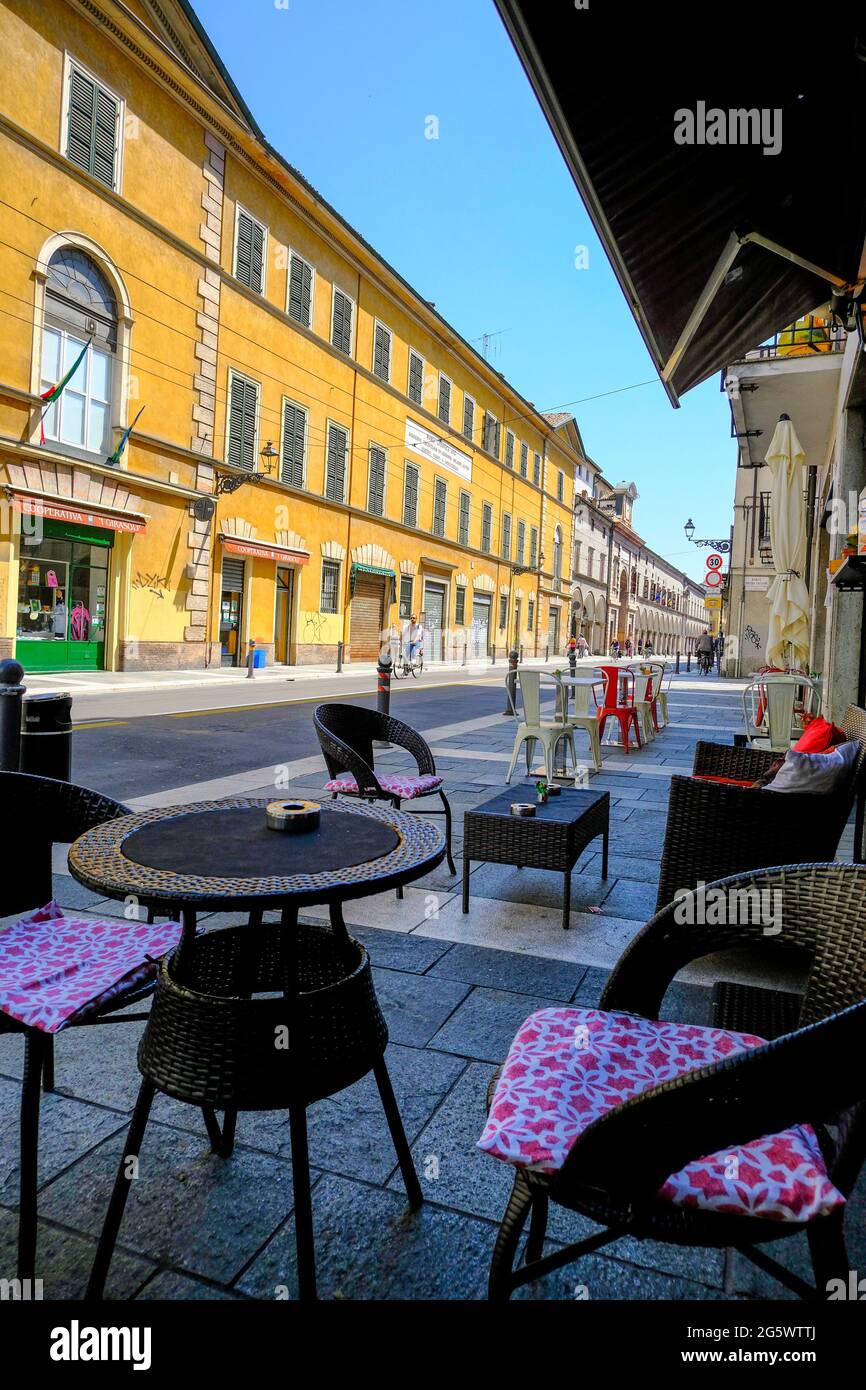 tables with chairs across colorful buildings in a restaurant terrace ...