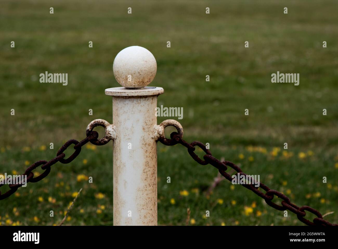 Old metal chain fence stanchion with chain fence in a country park ...