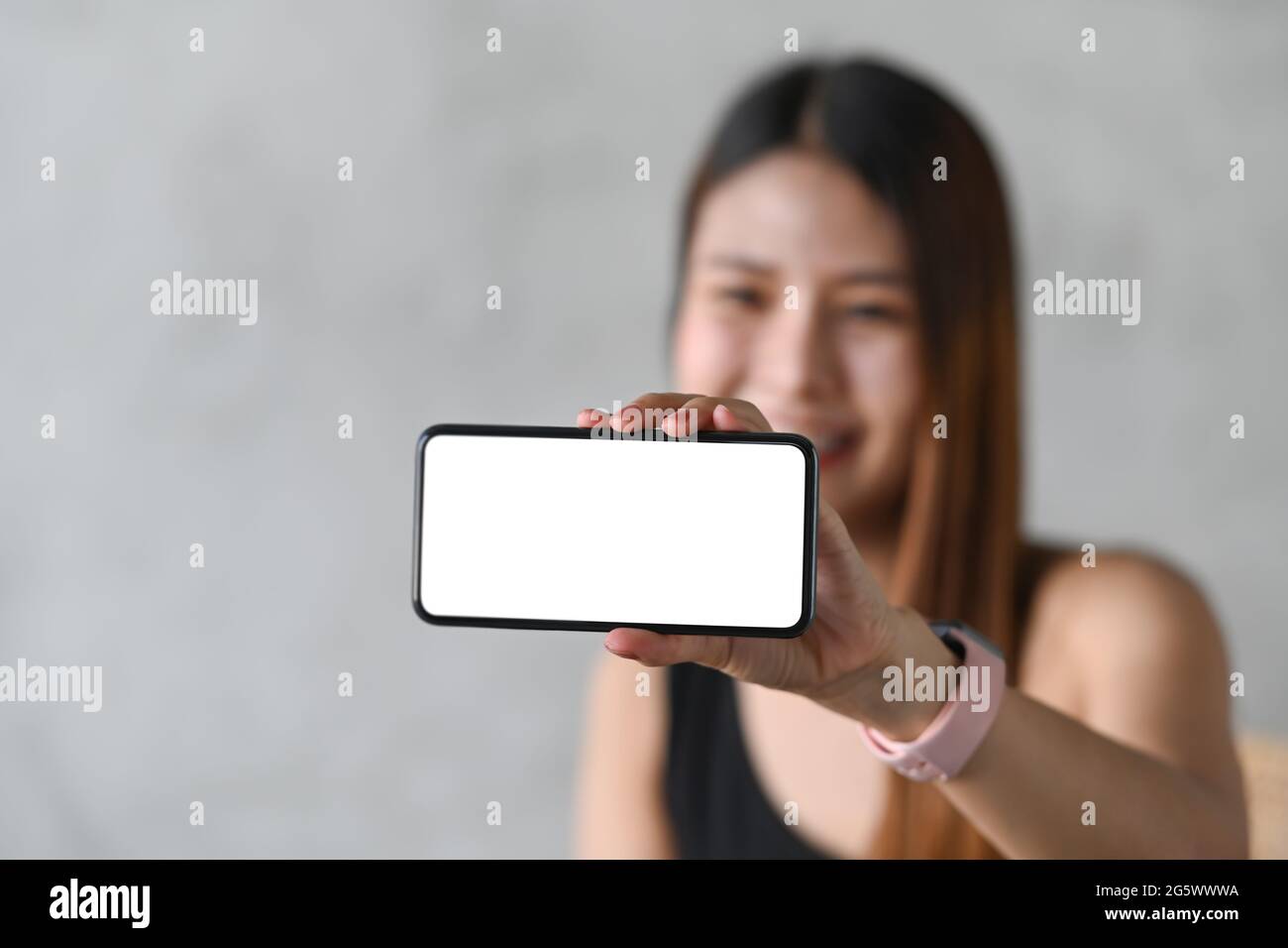 Happy woman showing horizontal mobile phone with empty screen Stock ...