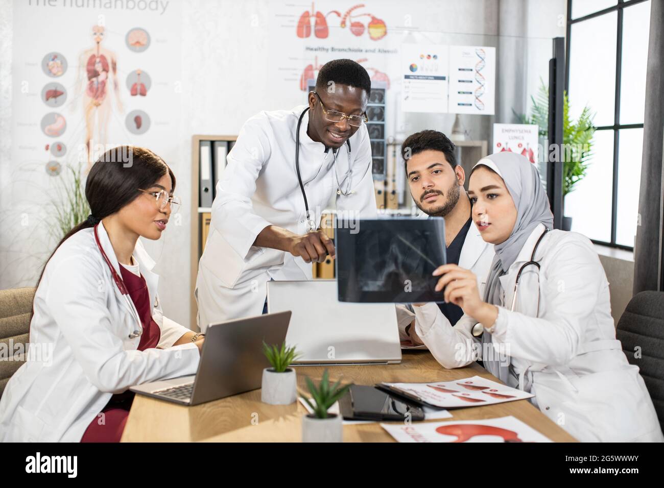 Multiethnic group of doctors gathering at conference room for analyzing ...