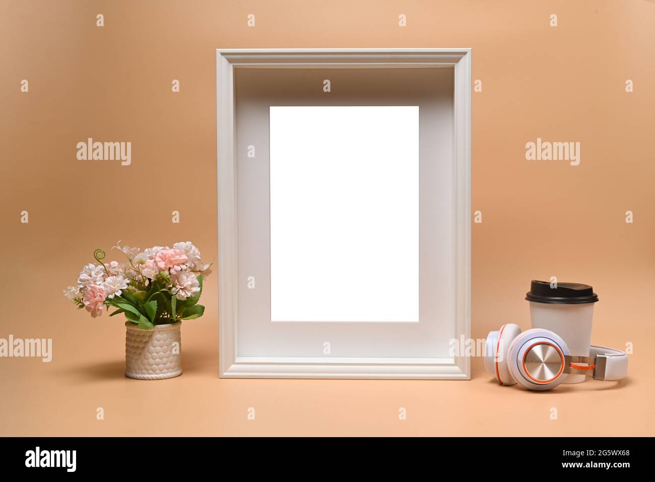 Picture frame, flower pot, coffee cup and headphone on beige background ...