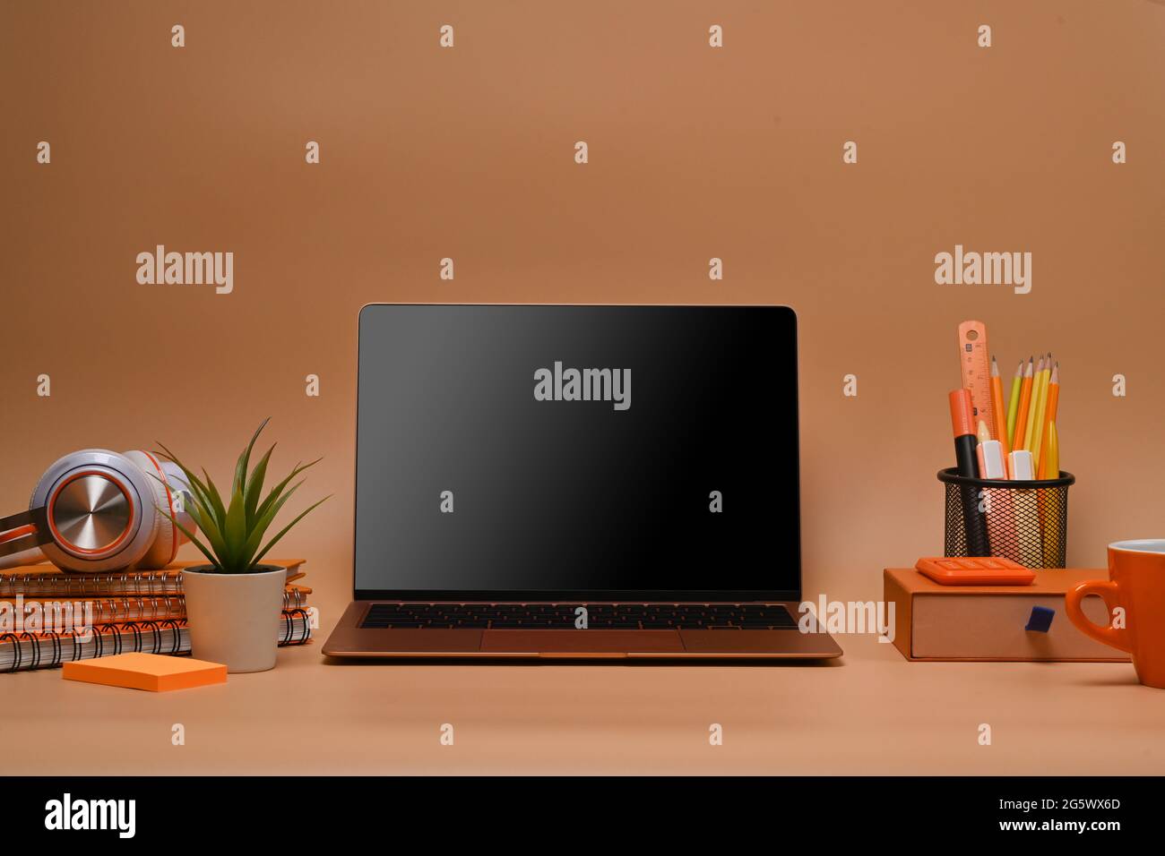 Front view laptop and equipment orange background Stock Photo - Alamy