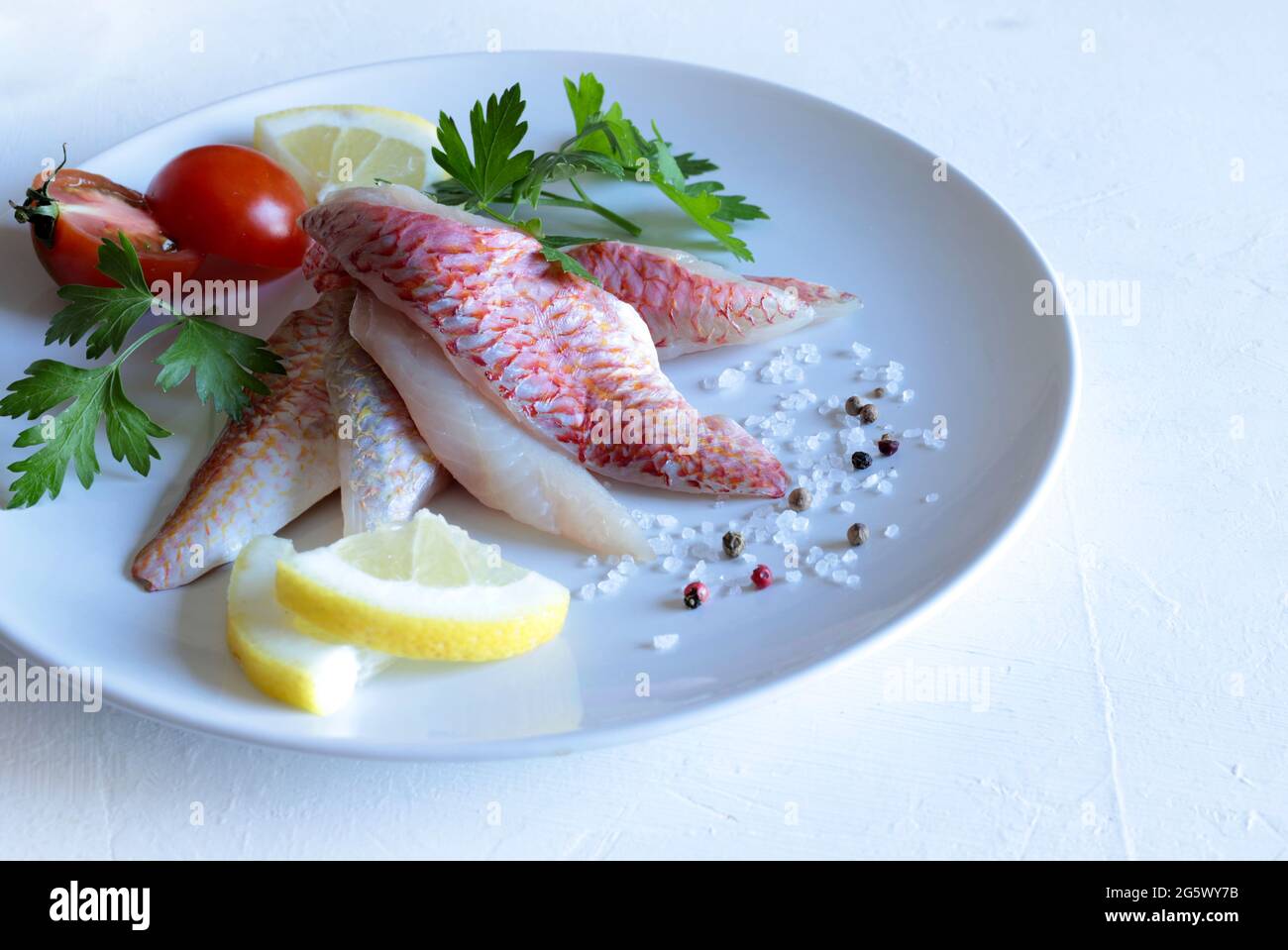 Fresh gurnard fillet with lemon on white plate Stock Photo - Alamy