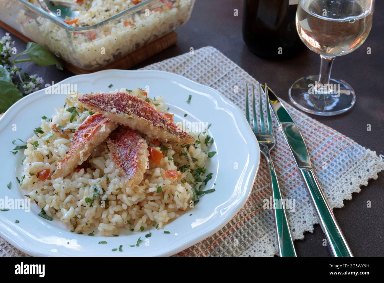 Baked gurnard fillet with rice on a plate on the table. Directly above ...