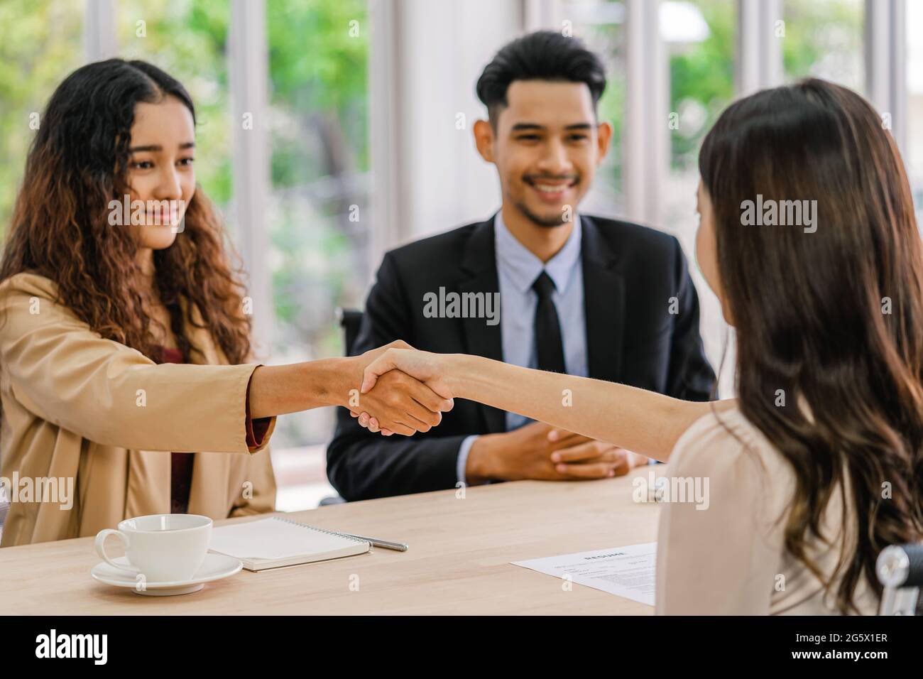 Closeup handshake after interview agreement between Young Asian woman ...
