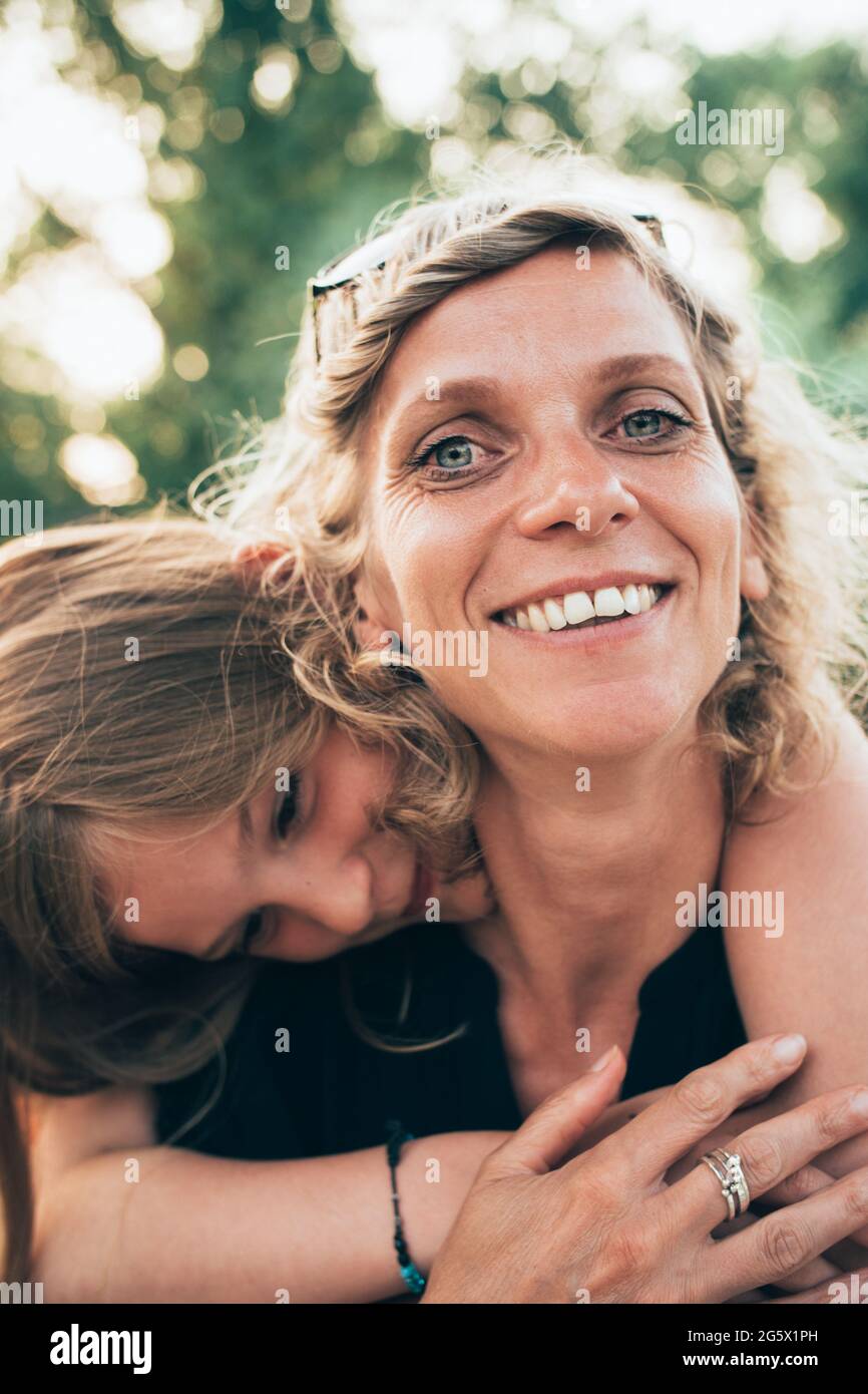 Mother and daughter togetherness in summer sun. Hugging each other ...