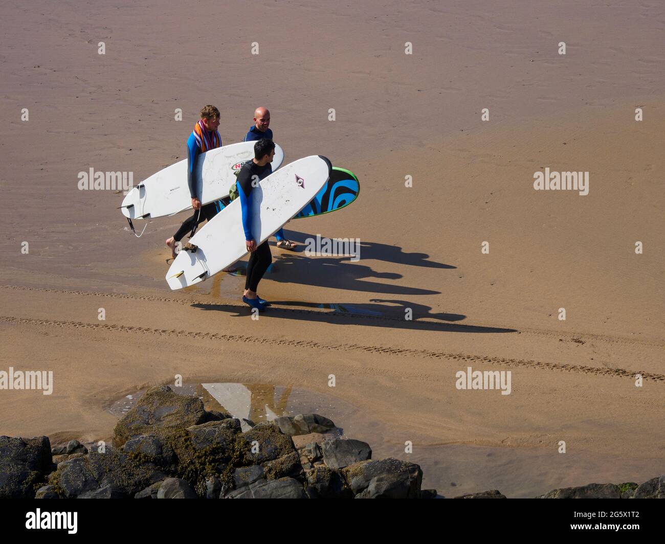 Three surfers heading for the sea, Cornwall, UK Stock Photo - Alamy