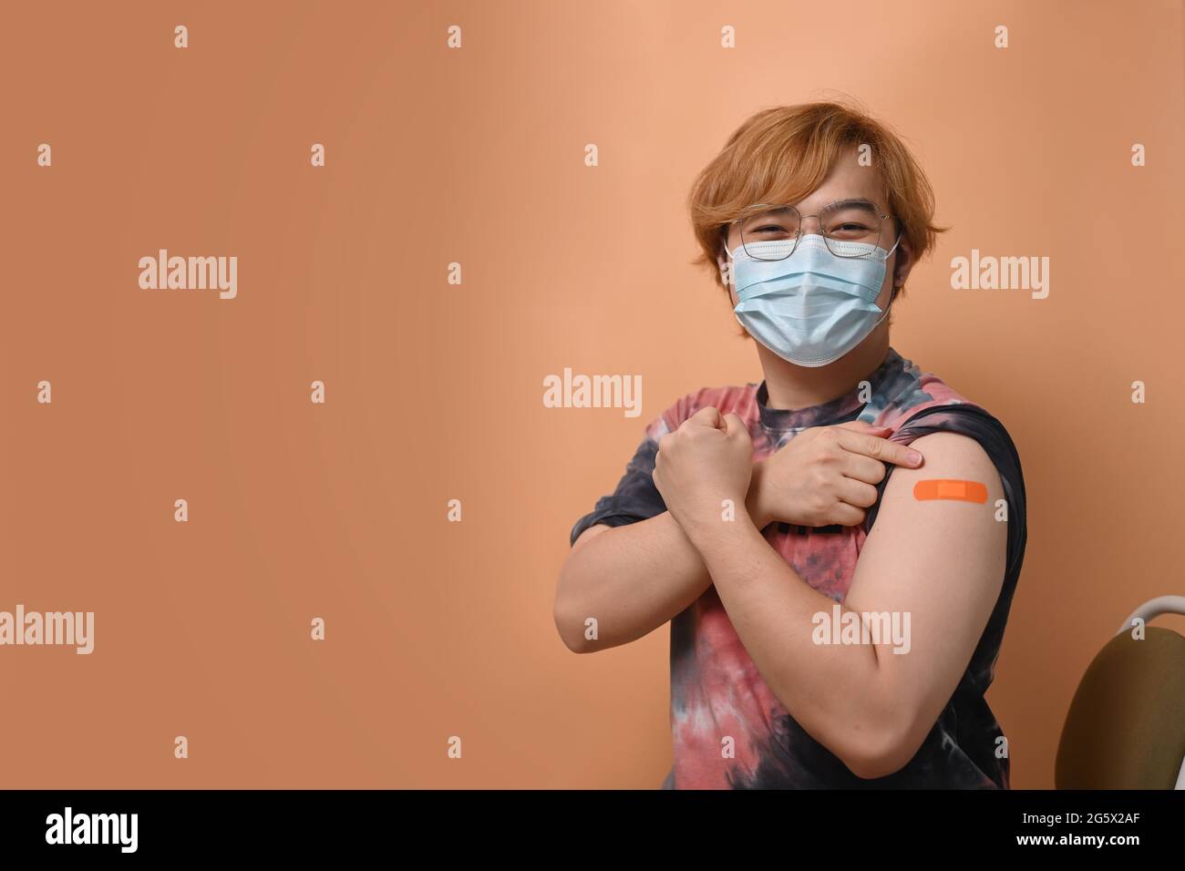 Happy young man showing arm after vaccine injection. Vaccination and ...