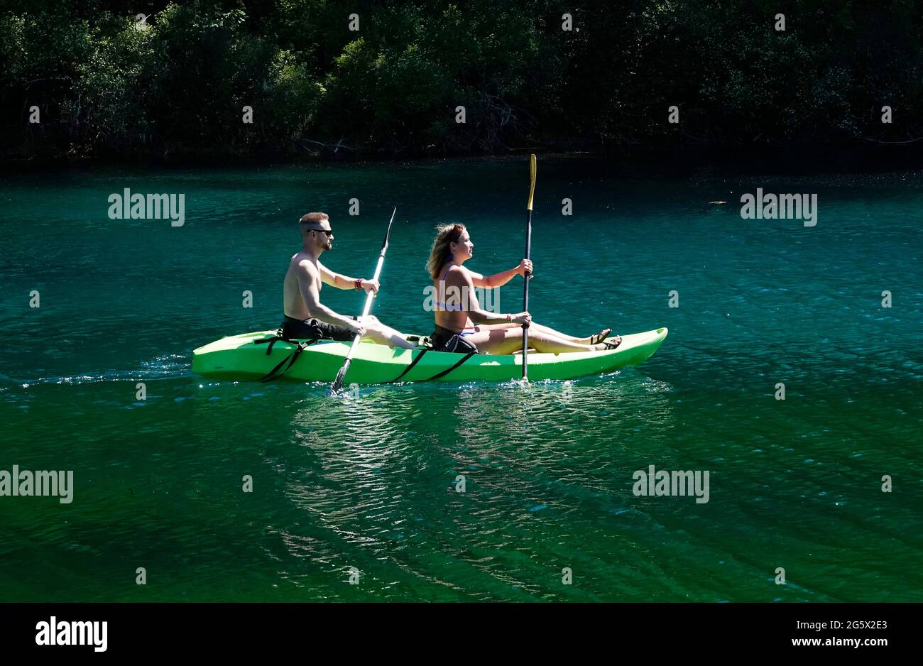 Young people cooling off in a two-person kayak on Clear Lake on a hot ...