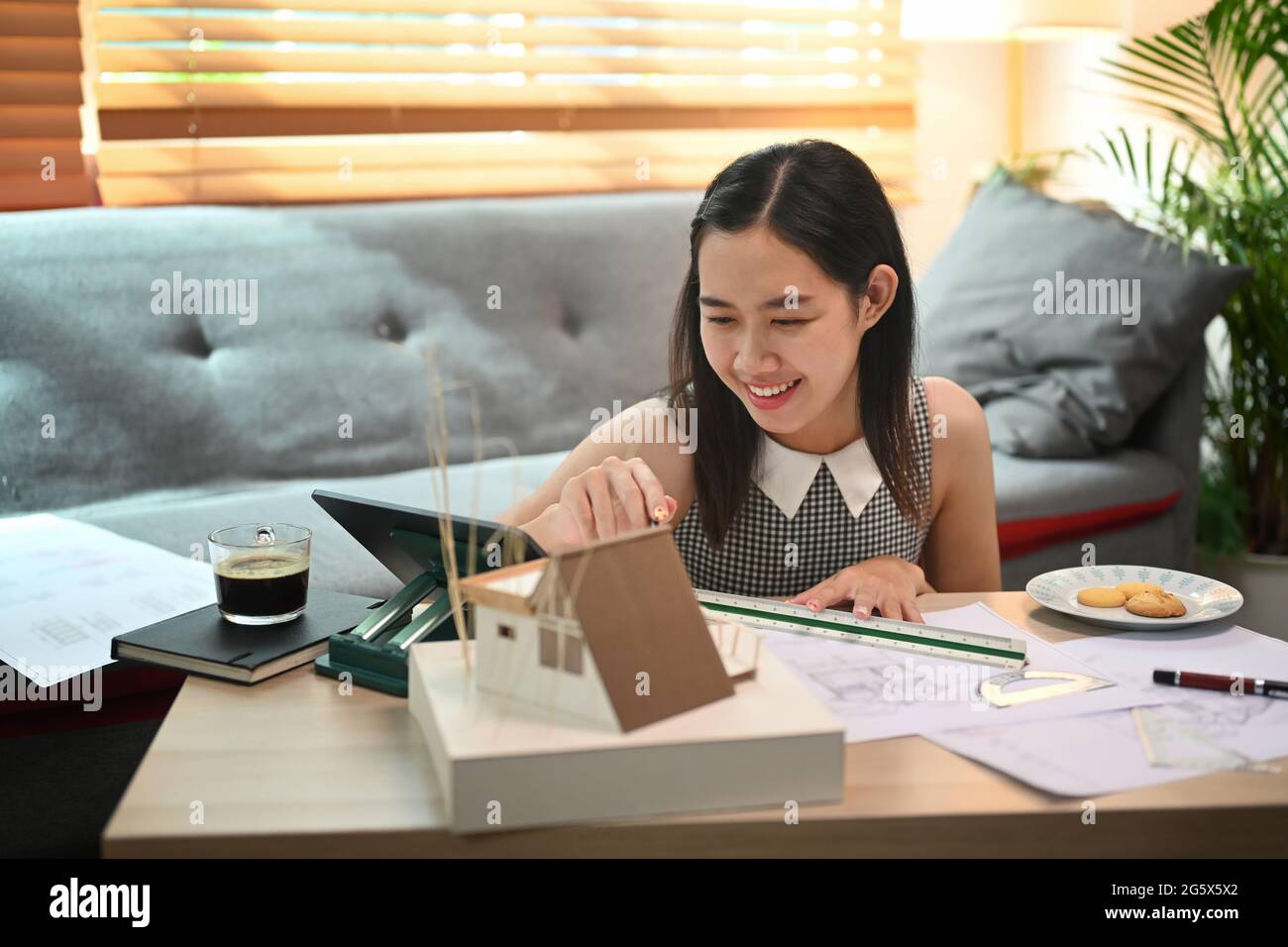 Smiling Architect woman working with computer tablet and blueprints at ...