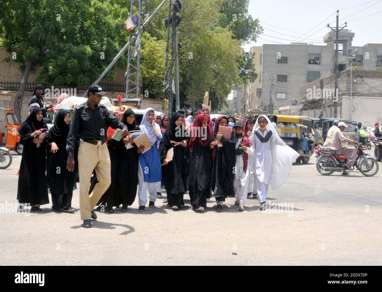Traffic police official helps students to cross the road during duty ...