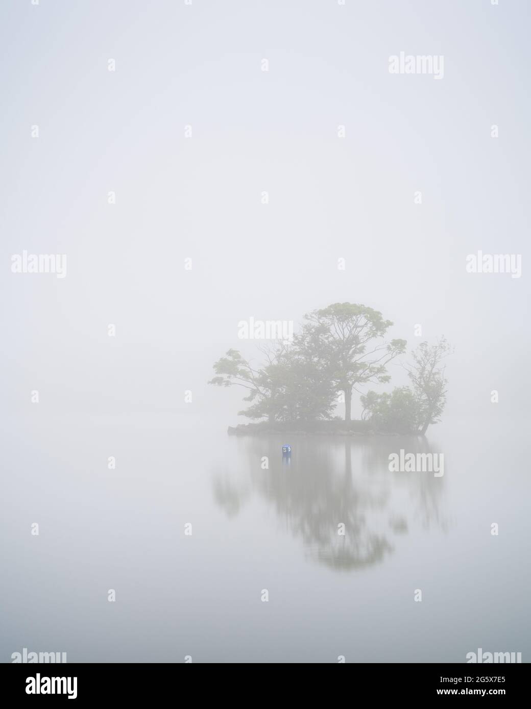 The small island on Yeadon Tarn (dam) is isolated by thick fog ...
