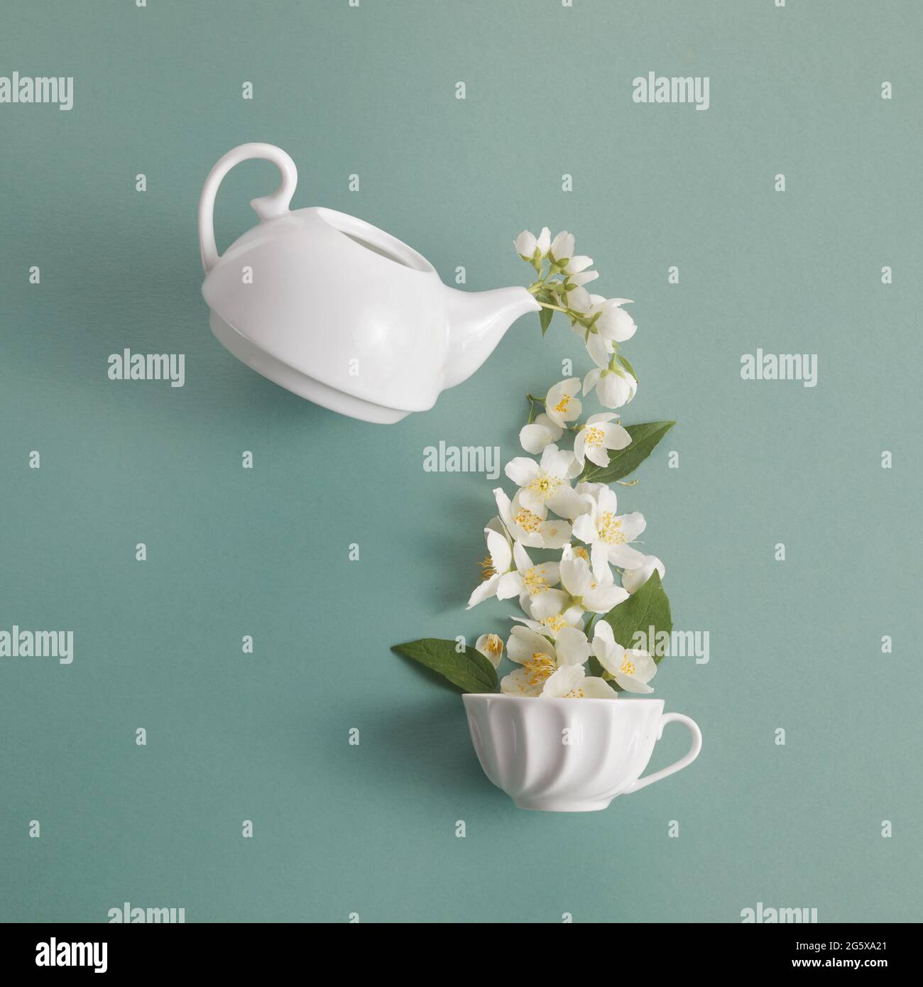 Layout of teapot and tea Cup with Jasmine flowers on a green background ...
