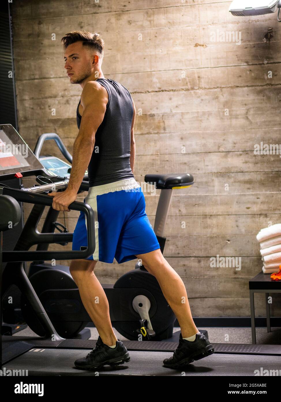 Blond young muscular man running on treadmill in gym Stock Photo - Alamy