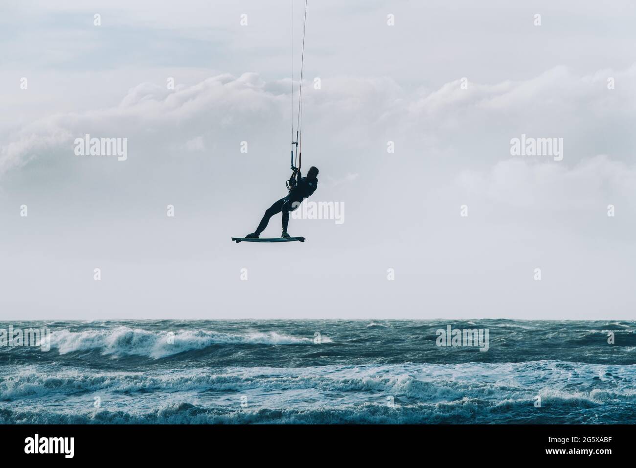 Kite surfing in storm in winter with extreme high jumps Stock Photo - Alamy