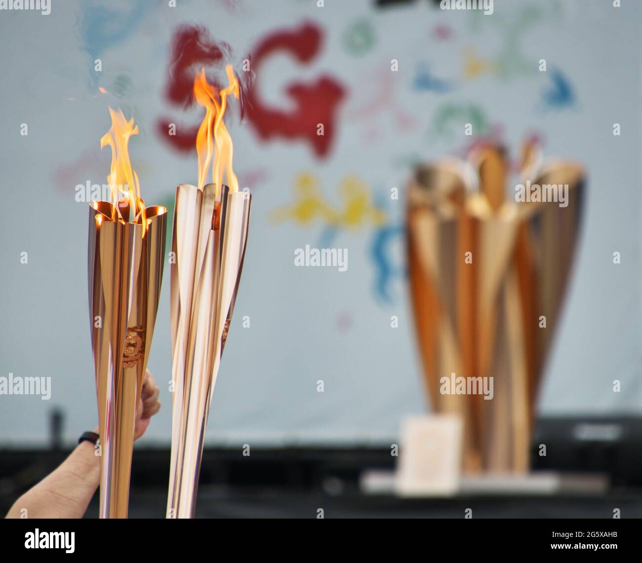 A torchbearer passes the flame during the Tokyo 2020 Olympic torch ...