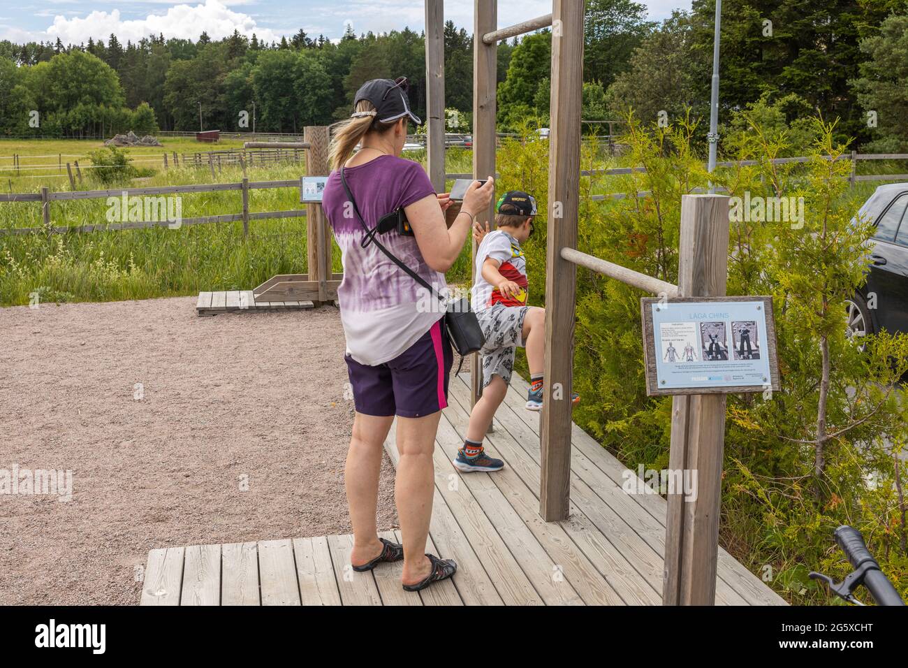 View of woman taking pictures of child playing on playground Stock ...