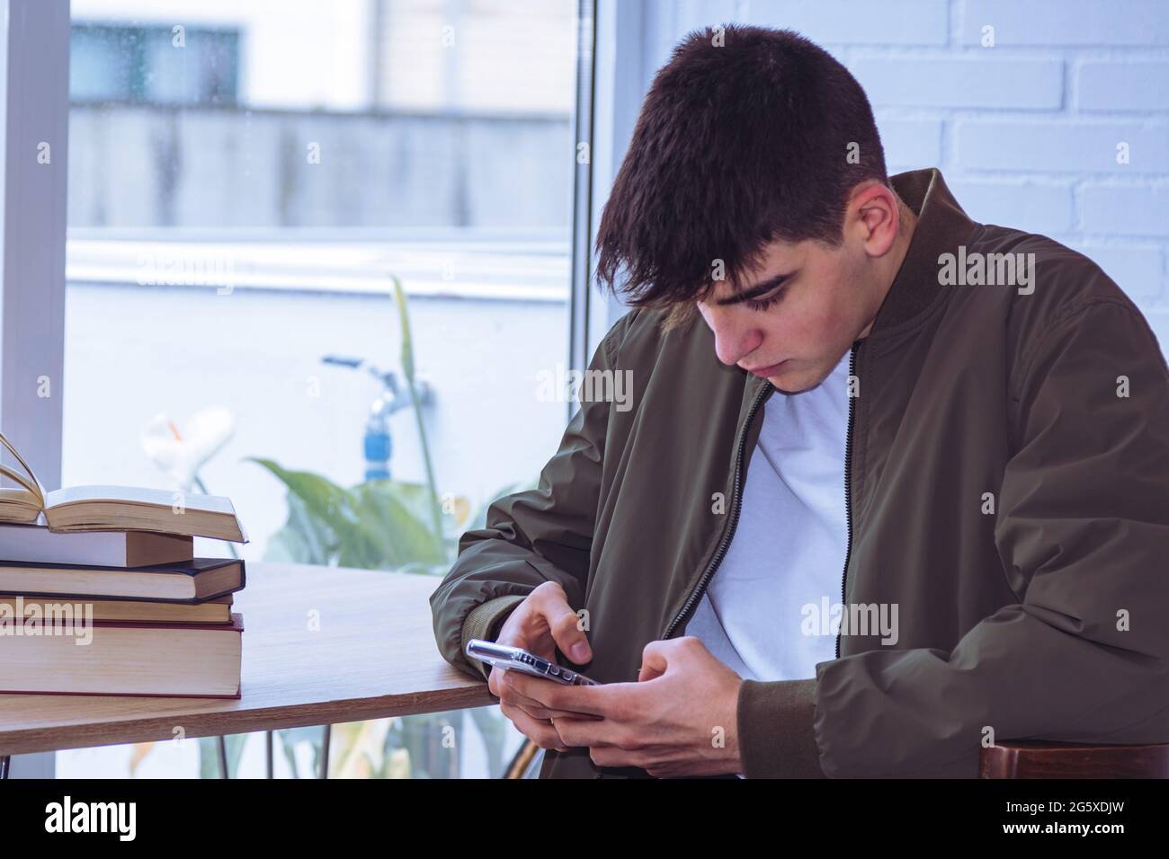 teen boy student with mobile phone at desk Stock Photo - Alamy