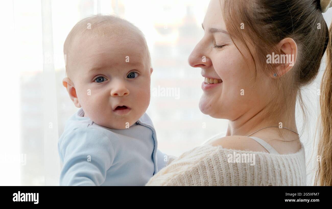 Cute little baby boy hugging mother and smiling in camera. Concept of ...
