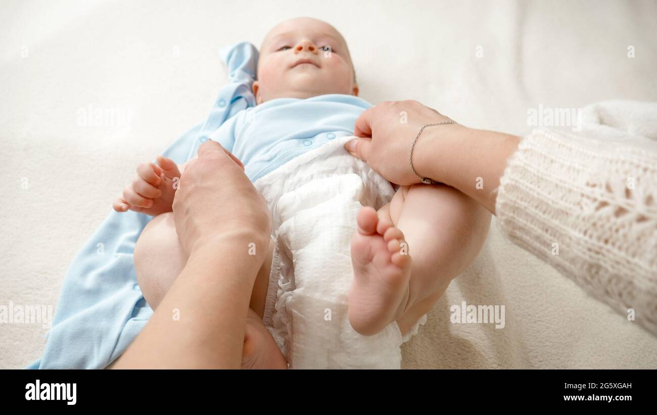 Closeup of mother changing diapers to her little newborn baby boy in ...