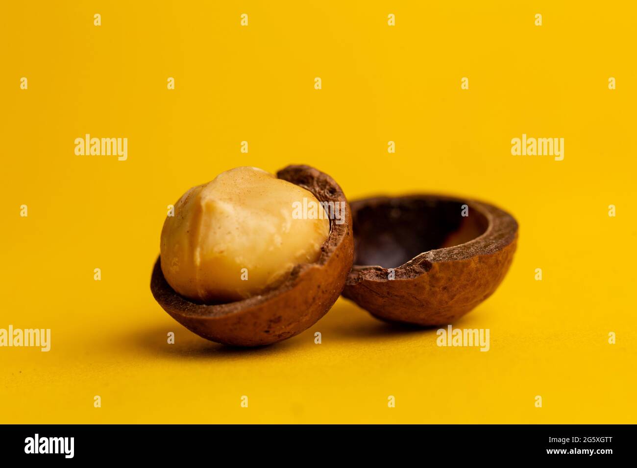 delicious and high-calorie macadamia nut on a yellow background Stock ...