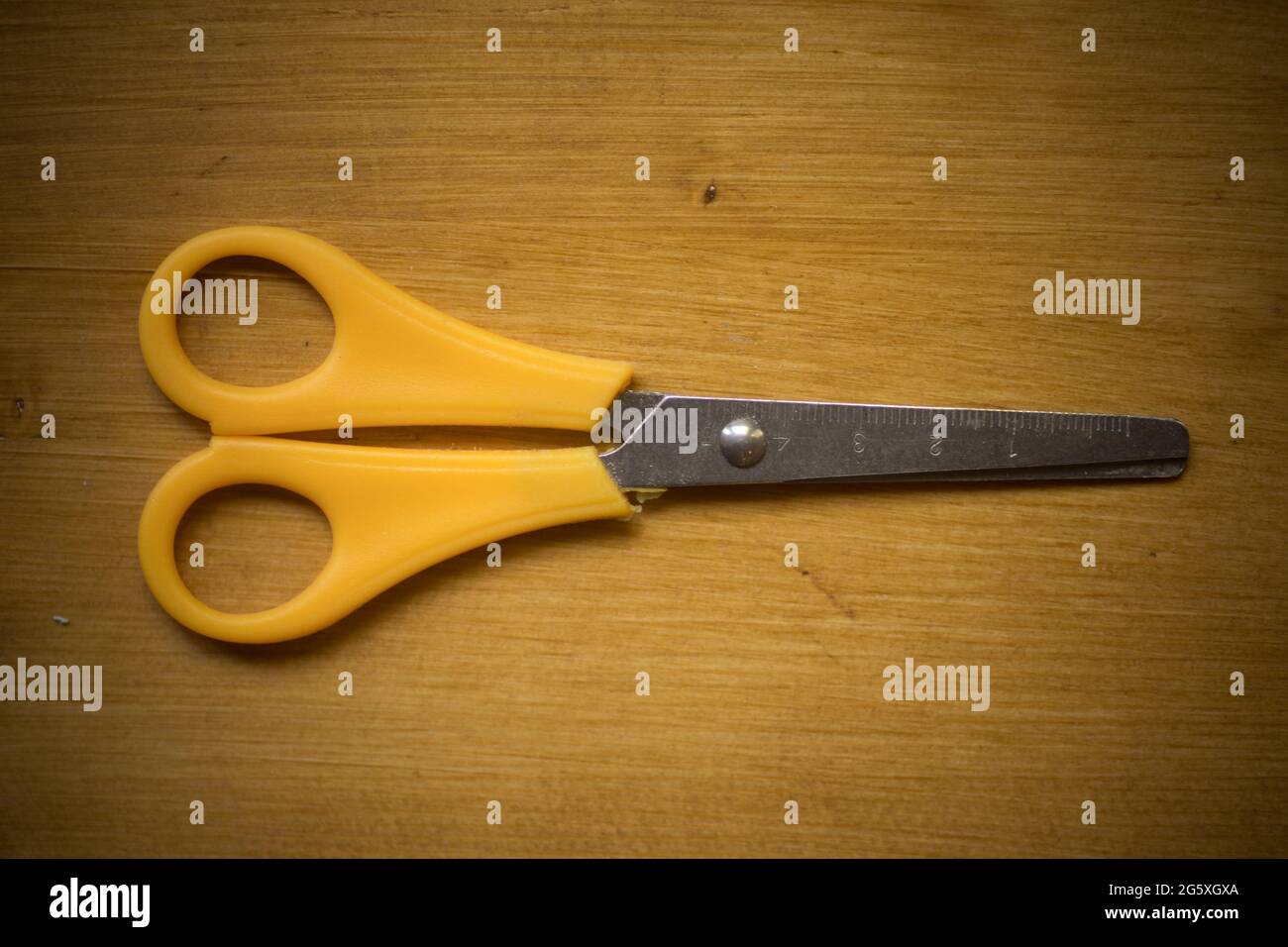 Yellow scissors with ruler isolated on wooden background Stock Photo ...