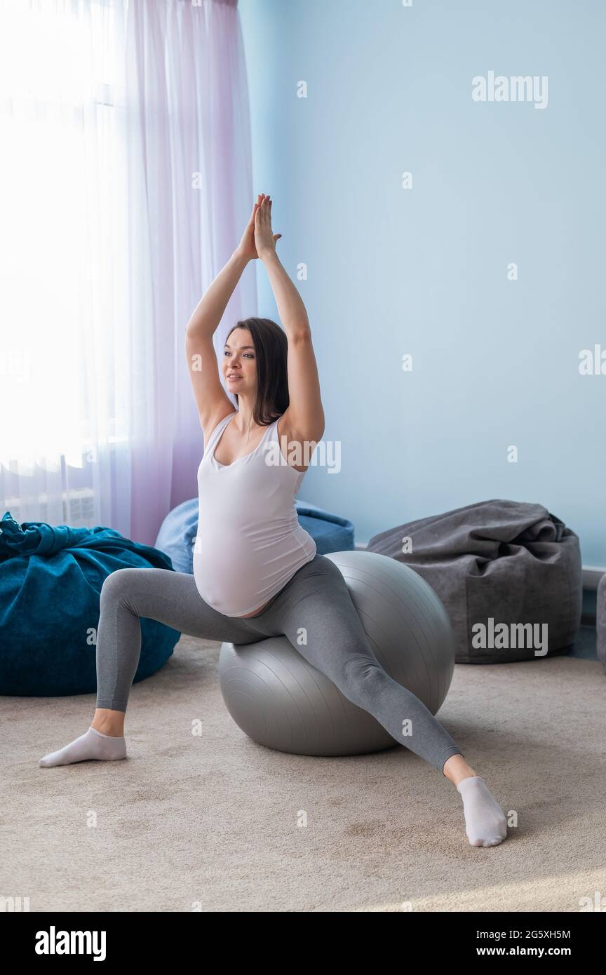 Beautiful european woman doing pregnant exercises. Expectant mother is ...