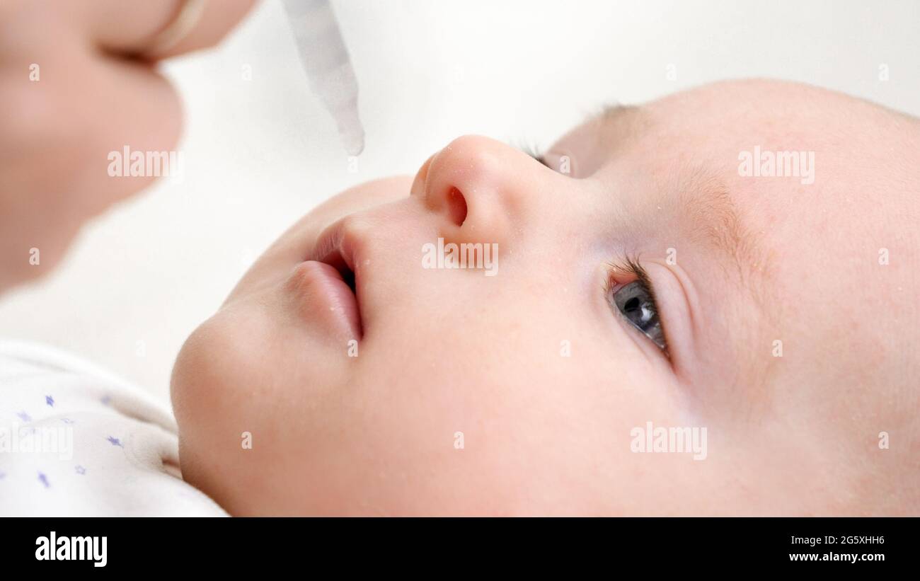 Giving vaccine or vitamins to baby from eyedropper. Concept of newborn ...