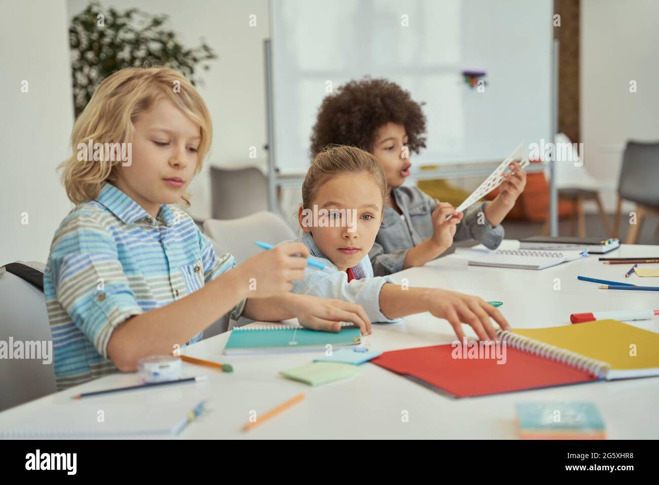 Social activity. Diverse kids sitting together at the table in ...