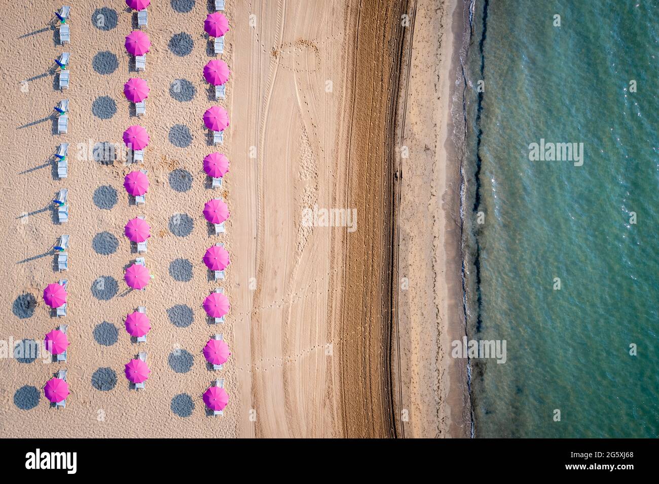Aerial view to a row of beach umbrella at the seaside. Typical view of ...
