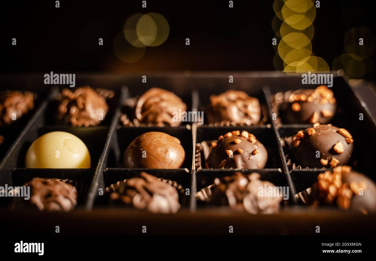 Delicious chocolate candies or truffle balls in box on table against ...