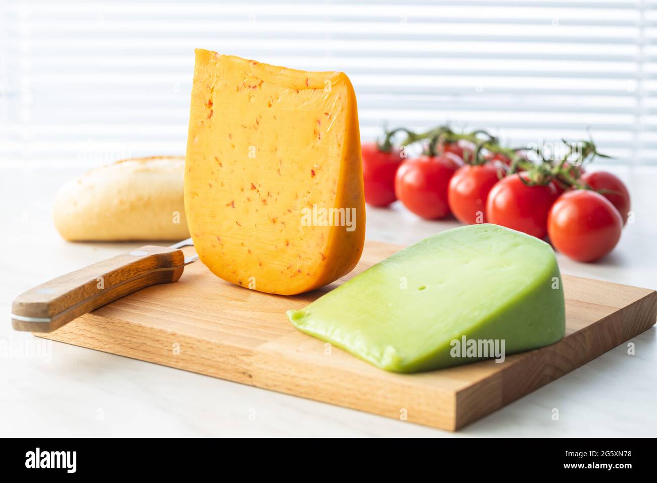 Block of hard cheese with chili and wasabi flavor on wooden cutting ...