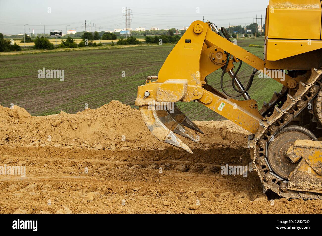 Asphalt road construction process. The bulldozer levels and compacts ...