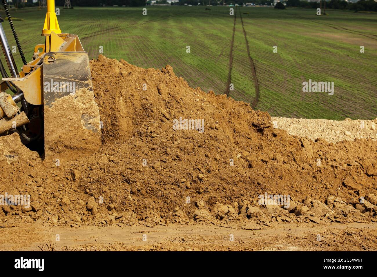 Asphalt road construction process. The bulldozer levels and compacts ...