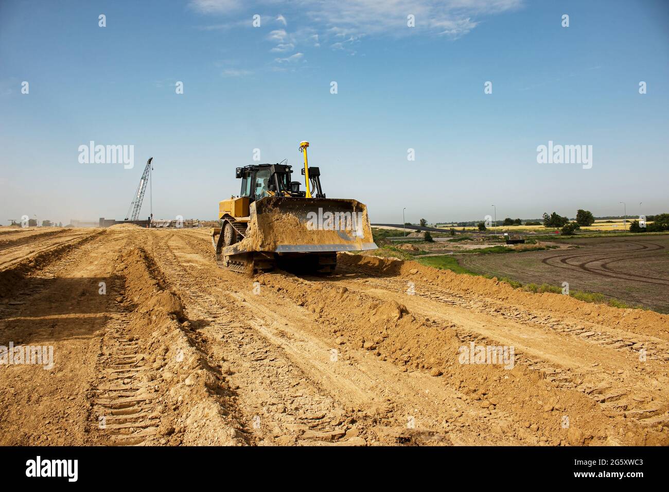 Asphalt road construction process. The bulldozer levels and compacts ...