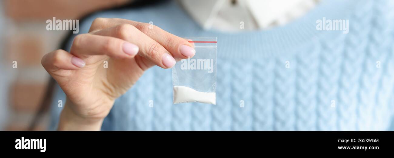 Woman holds small packet of white powder in her hands Stock Photo - Alamy
