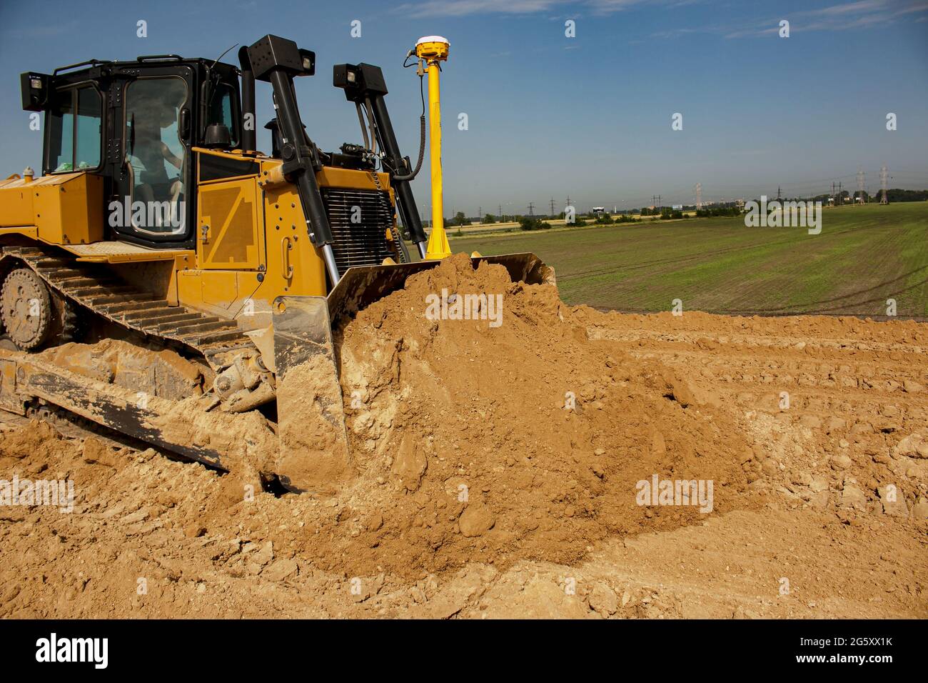 Asphalt road construction process. The bulldozer levels and compacts ...