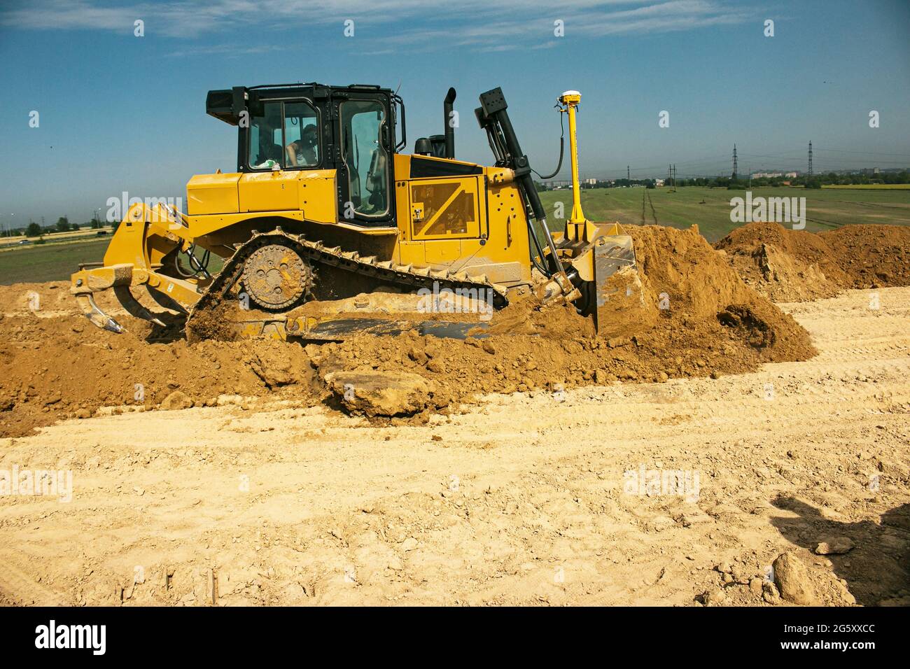 Asphalt road construction process. The bulldozer levels and compacts ...