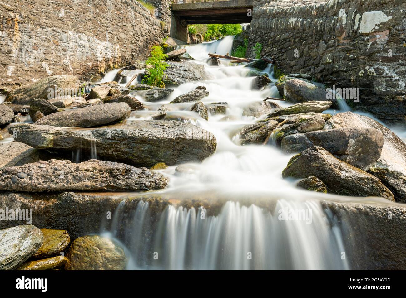 Long exposure of a waterfall flowing onto Lee Abbey Beach in Devon ...