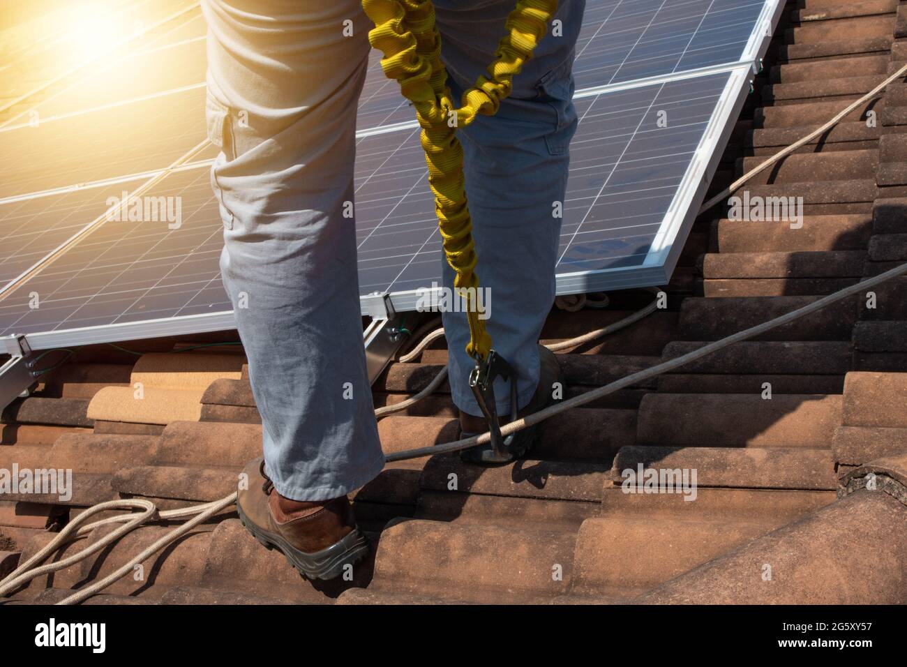 Solar worker cleaning photovoltaic panels with brush and water ...