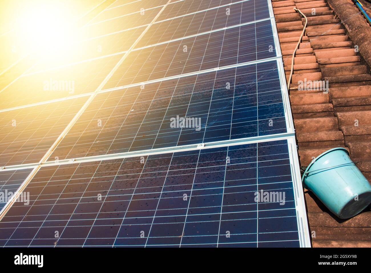 Solar worker cleaning photovoltaic panels with brush and water ...