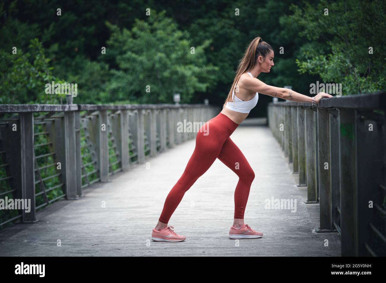 Athlete and runner girl stretching her legs Stock Photo - Alamy