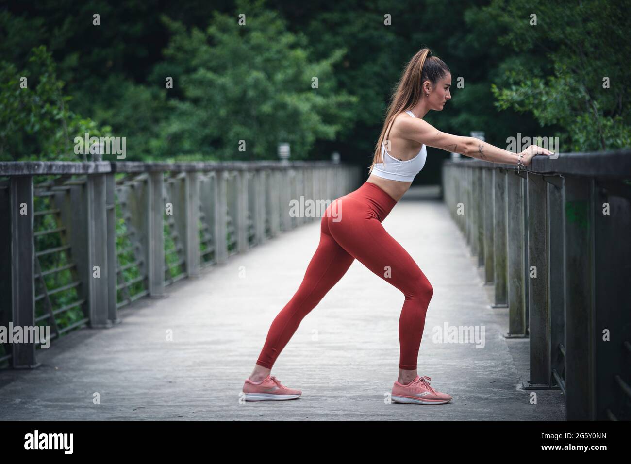 Athlete and runner girl stretching her legs Stock Photo - Alamy