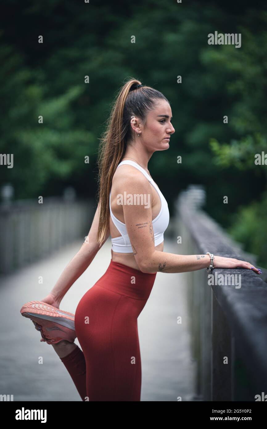 Athlete and runner girl stretching her legs Stock Photo - Alamy